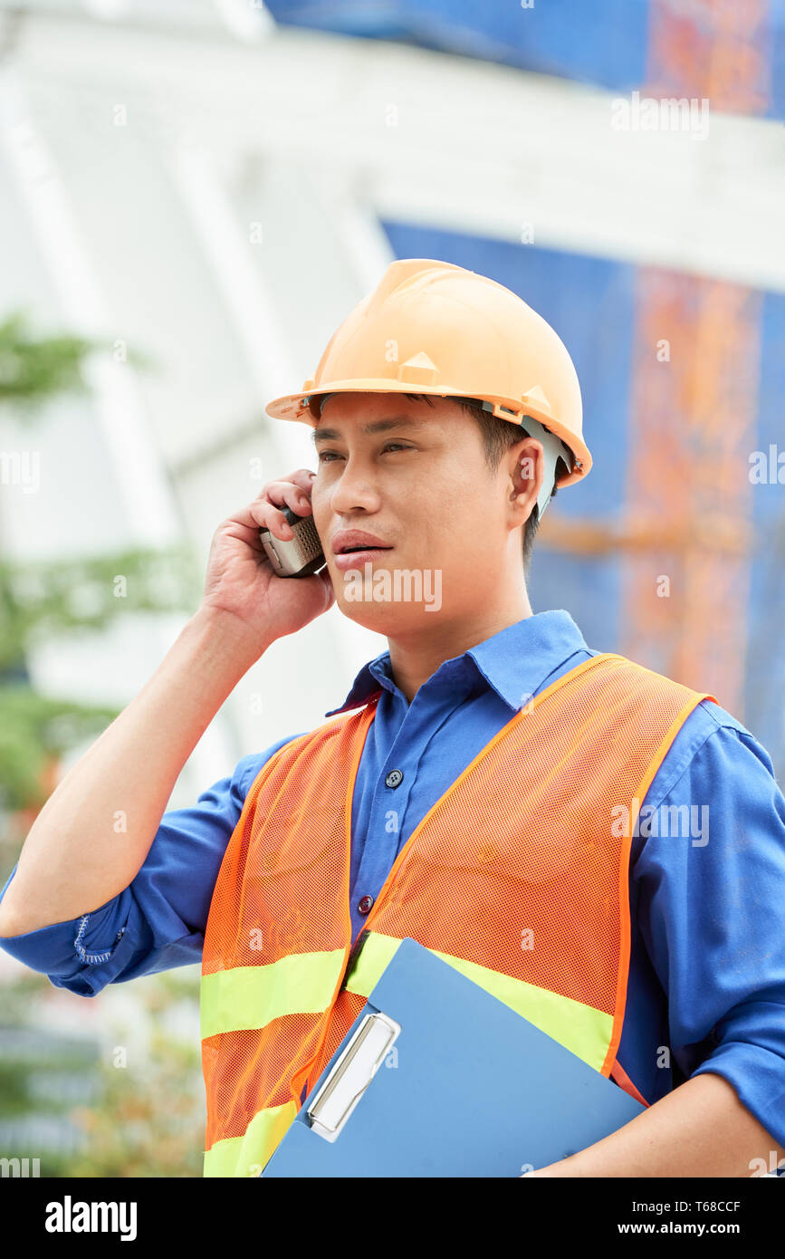 Engineer has a business talk on the phone outdoors Stock Photo - Alamy