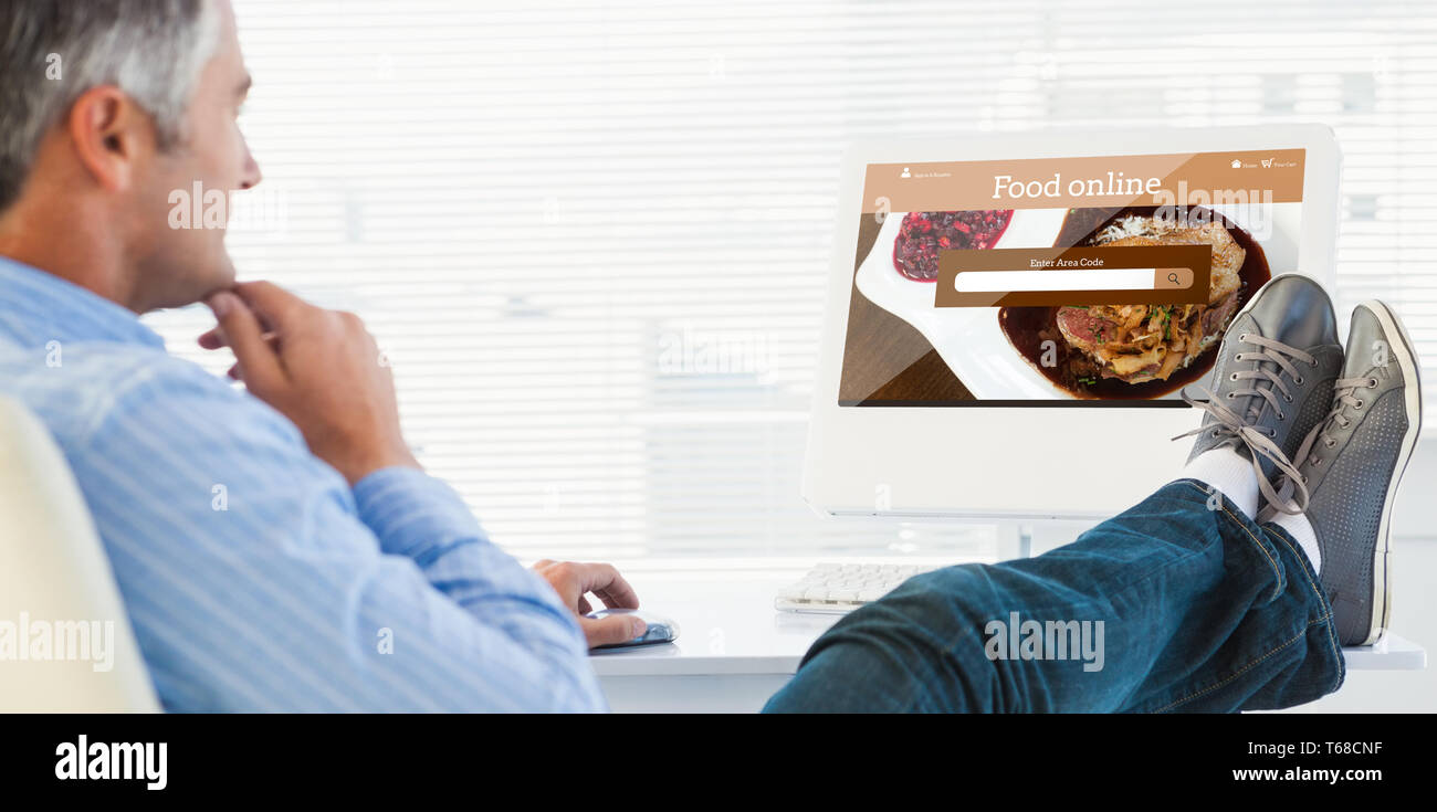 Composite image of relaxed man with feet on desk using computer Stock ...