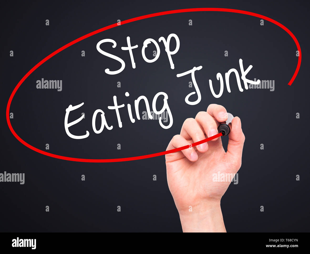 Man Hand writing Stop Eating Junk with black marker on visual screen ...