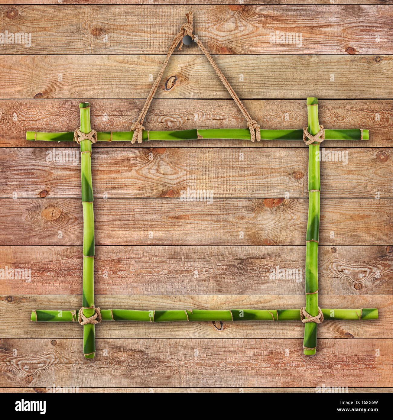 Green bamboo frame on natural wooden surface Stock Photo - Alamy