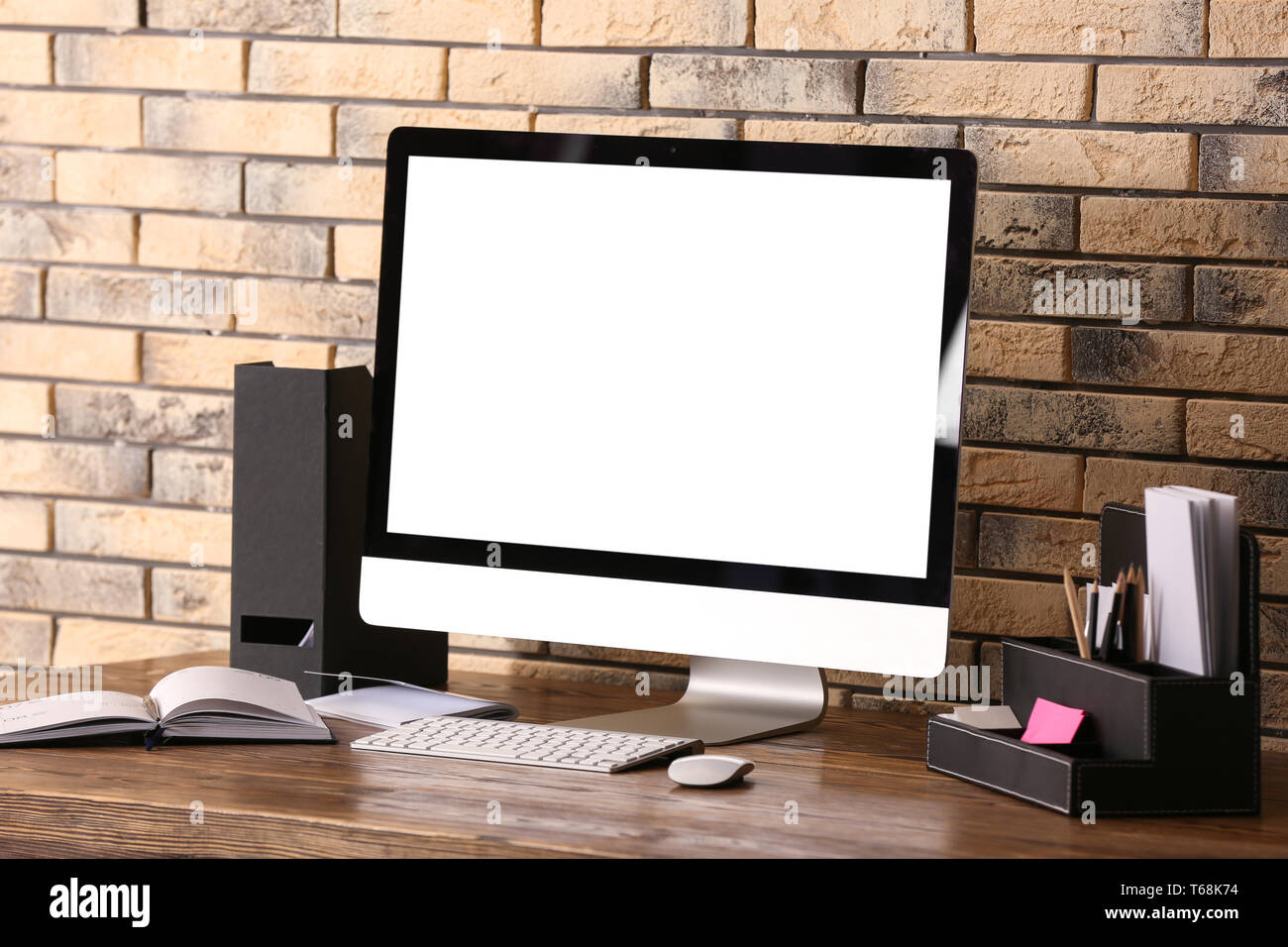 Workplace with computer on table near brick wall Stock Photo - Alamy