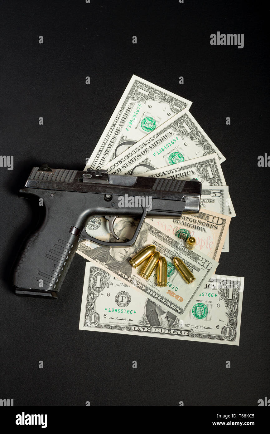 gun with bullet on US dollar banknotes Stock Photo - Alamy