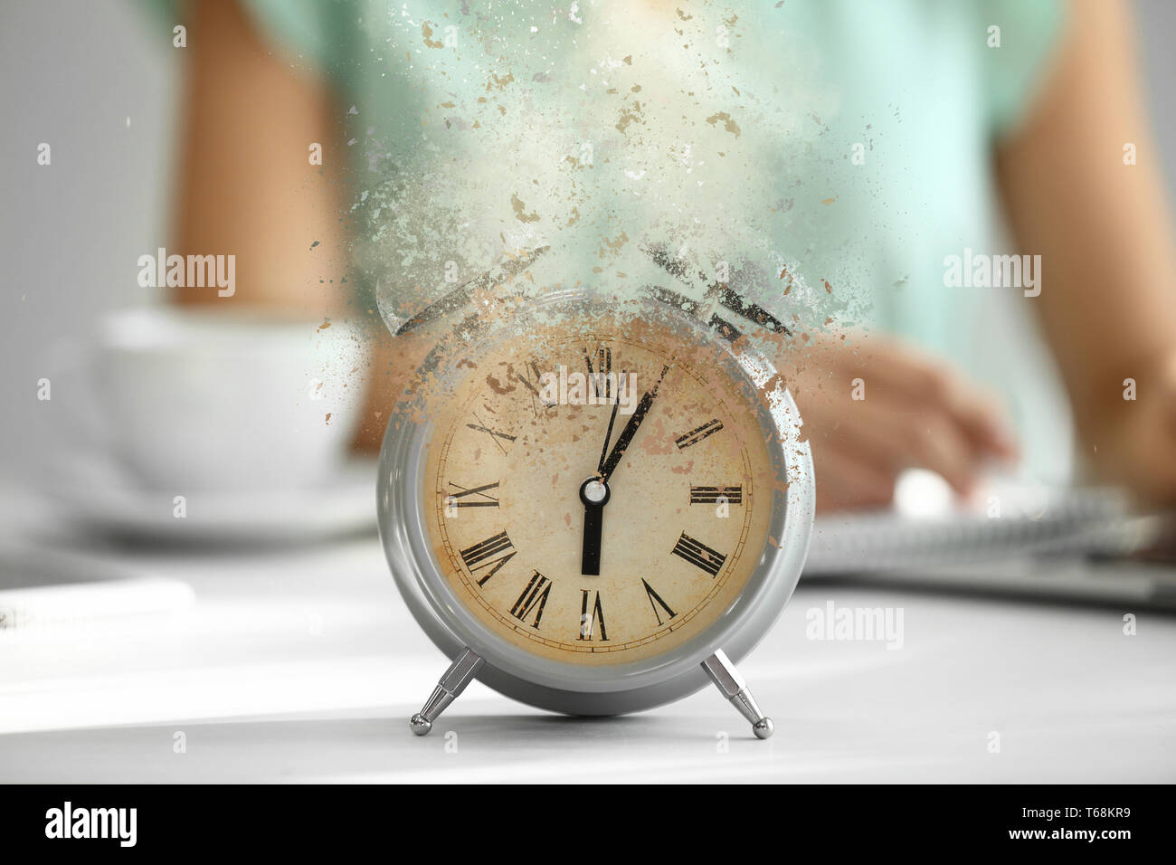 Crumbling alarm clock on white table in office Stock Photo - Alamy