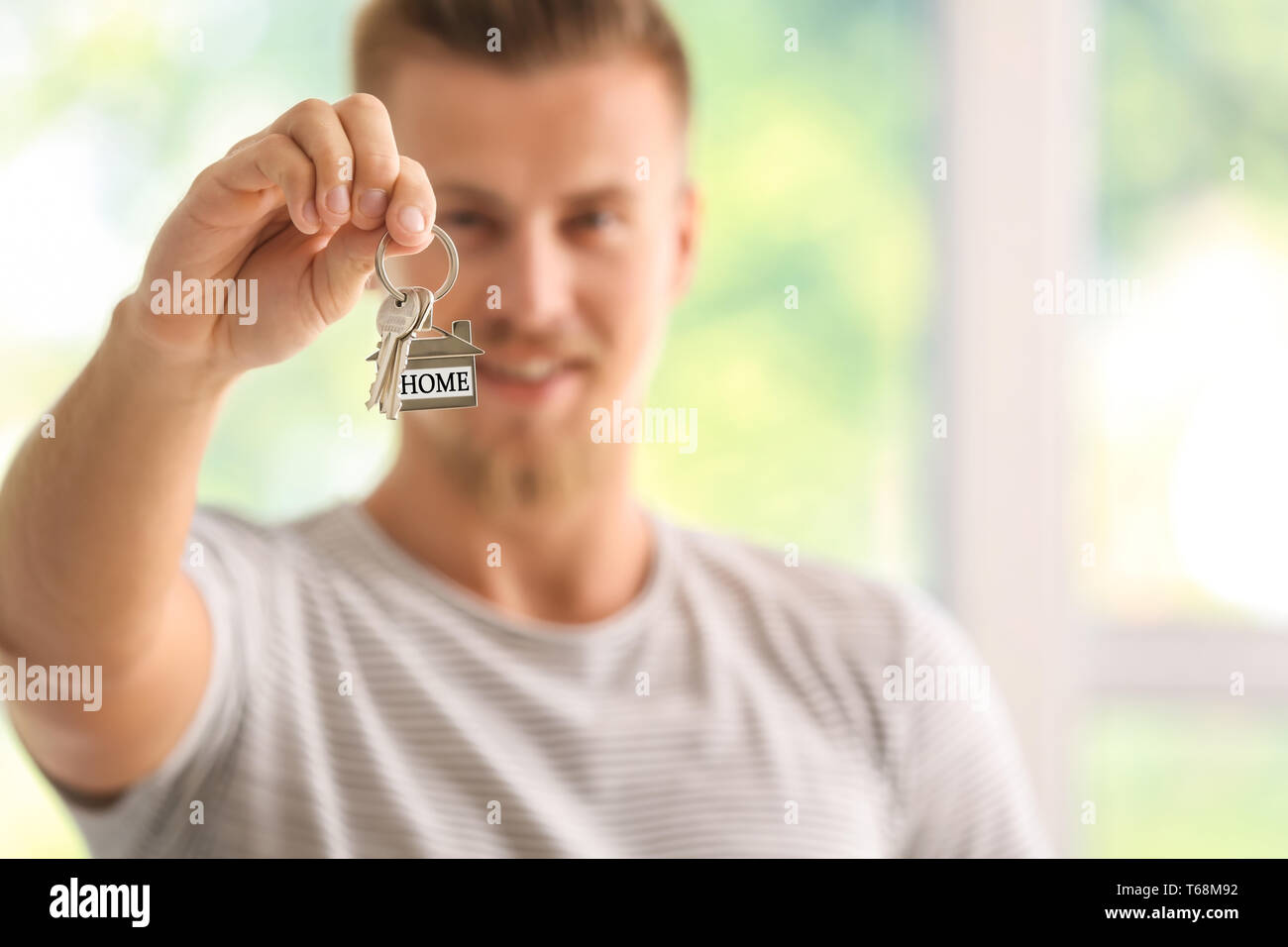 Happy young man with key from his new house Stock Photo - Alamy