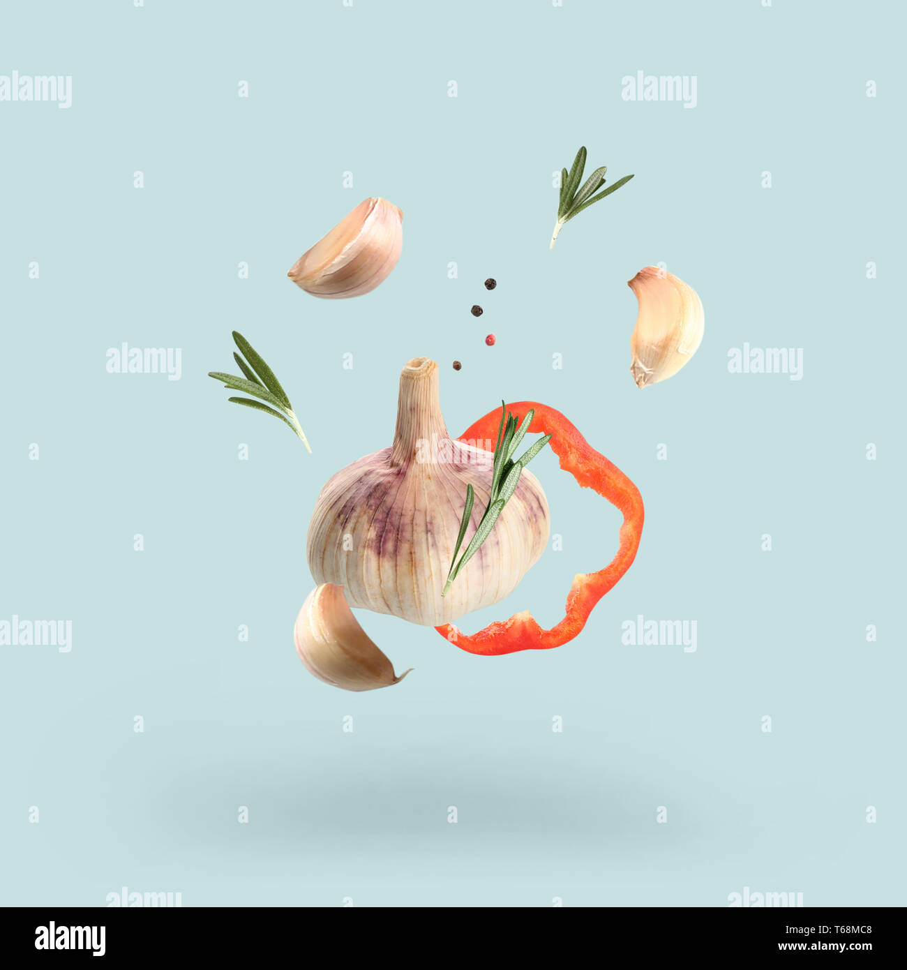 Falling vegetables with spices on blue background Stock Photo - Alamy