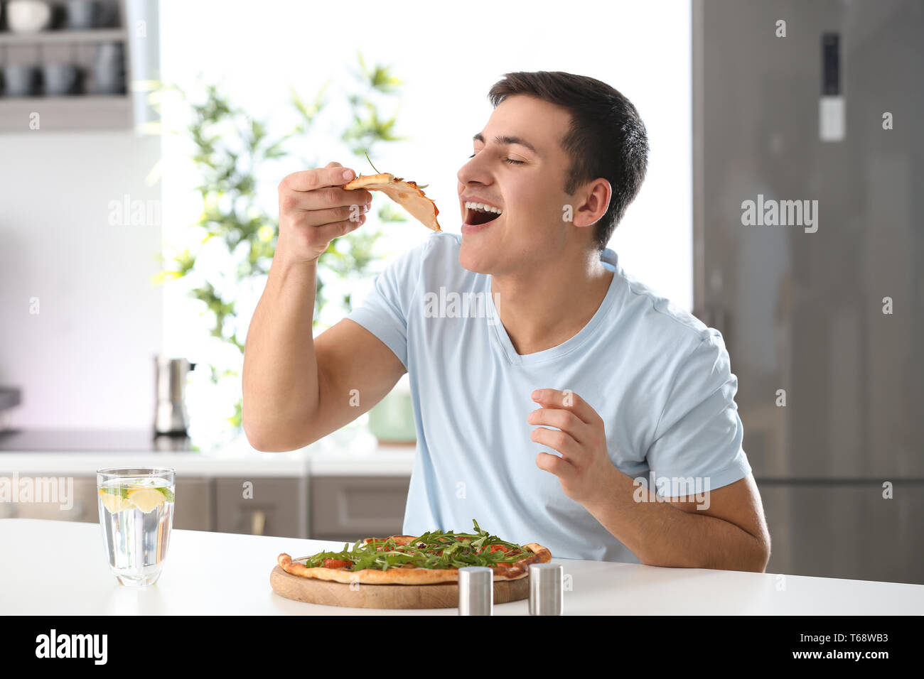 Young man eating tasty hi-res stock photography and images - Alamy