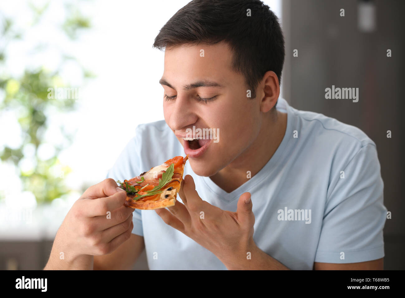 Young man eating tasty hi-res stock photography and images - Alamy