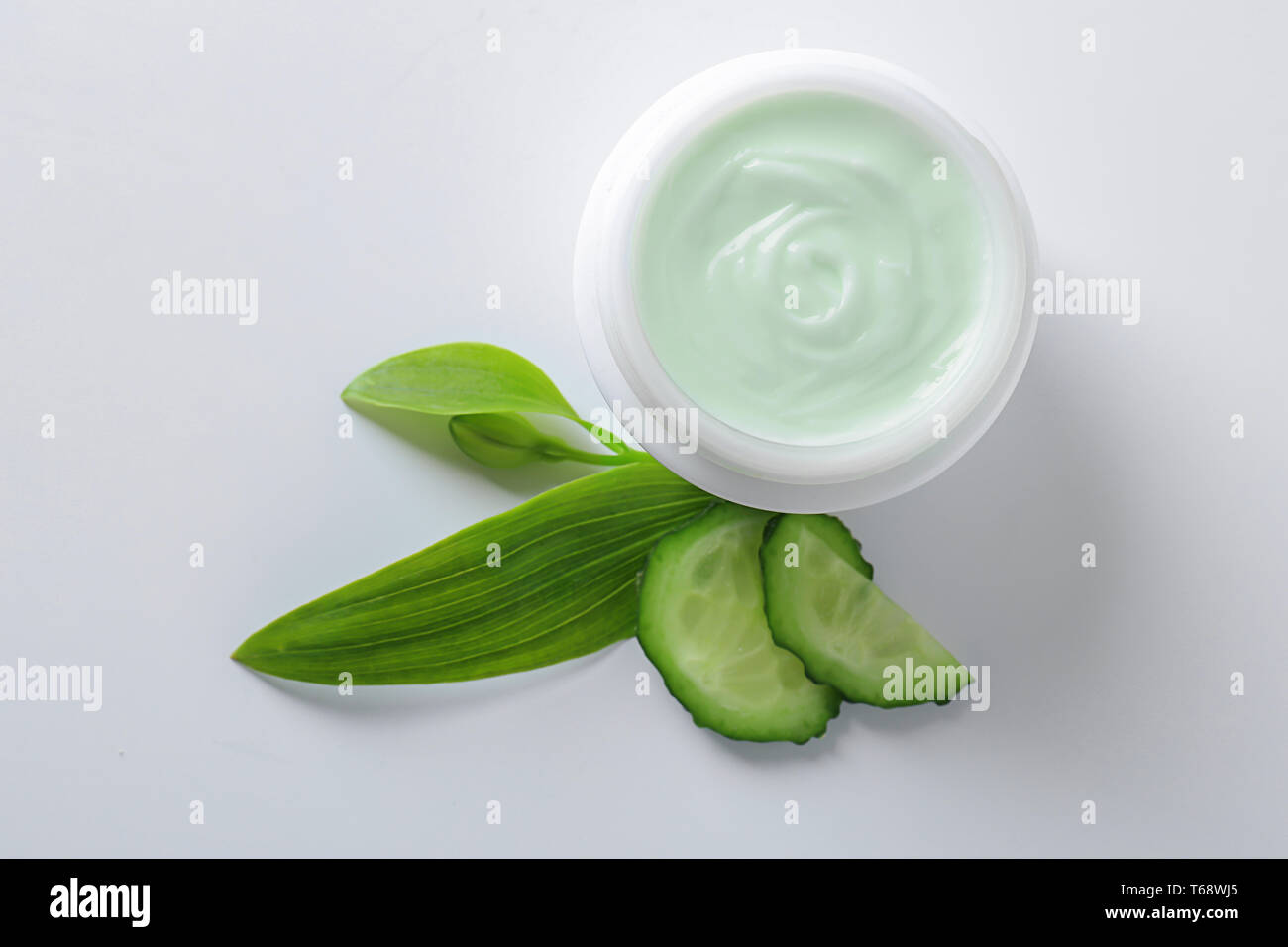 Body cream and cucumber slices on white background Stock Photo - Alamy