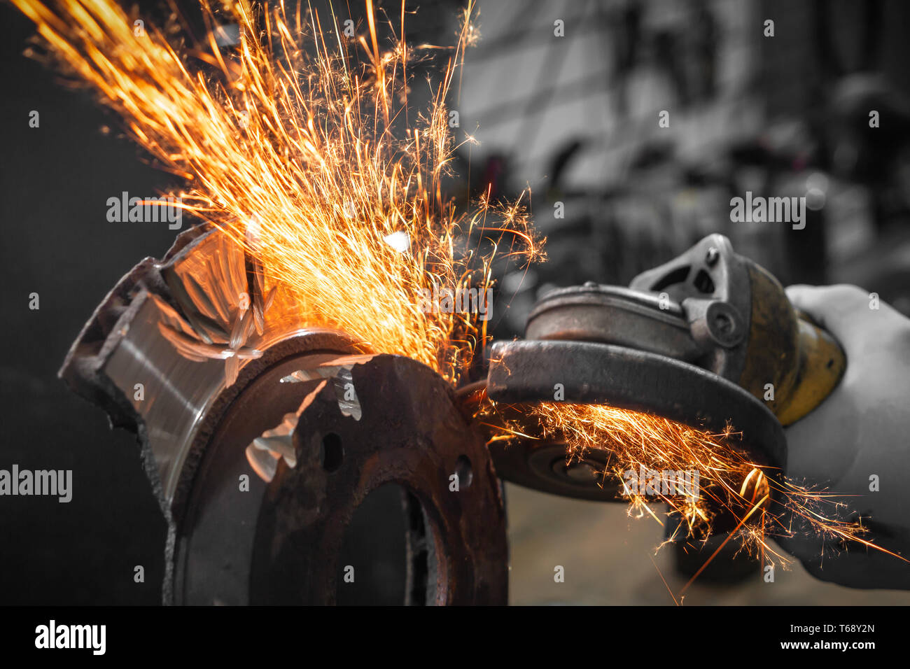 Close-up of a man sawing bearing metal with a hand circular saw, bright ...