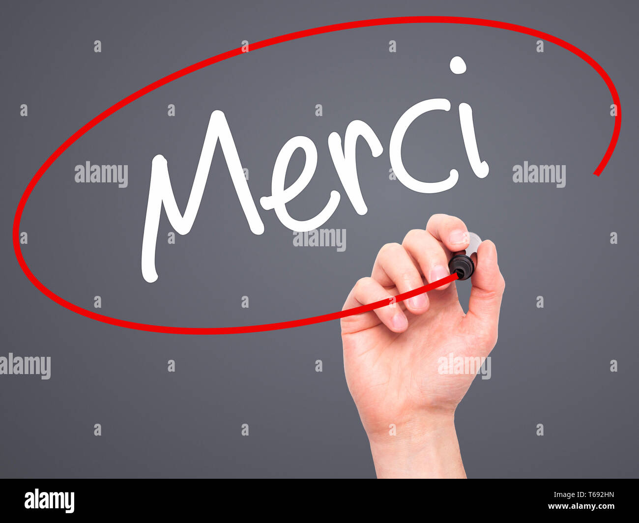 Man Hand writing Merci (Thank You In French) with black marker on ...