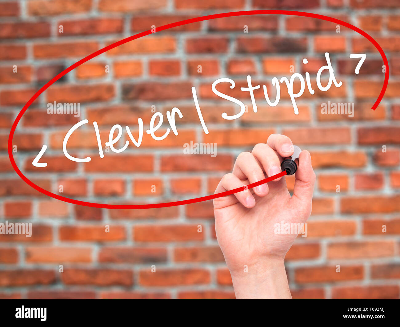 Man Hand writing Clever - Stupid with black marker on visual screen ...