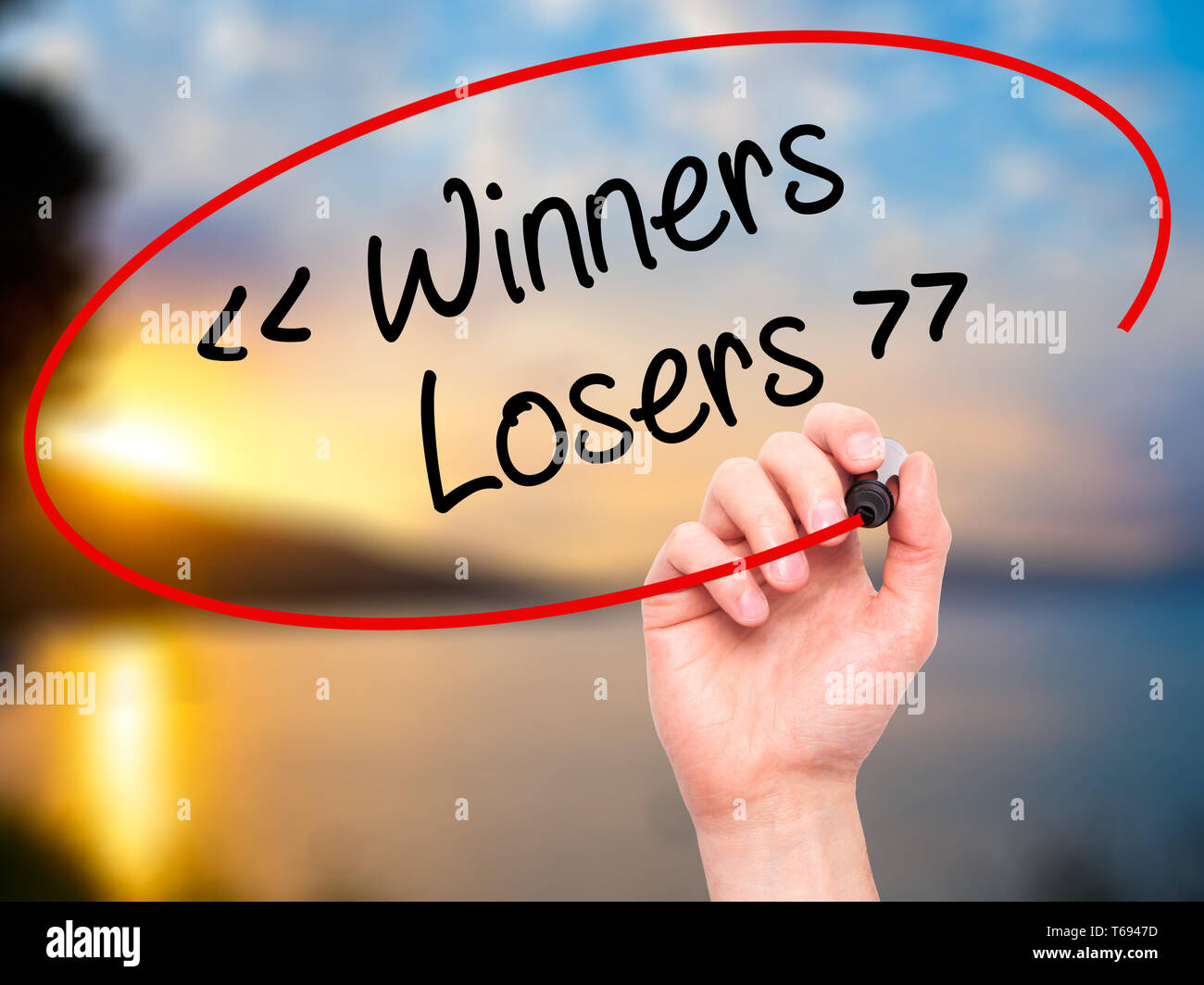 Man Hand writing Winners - Losers with black marker on visual screen ...