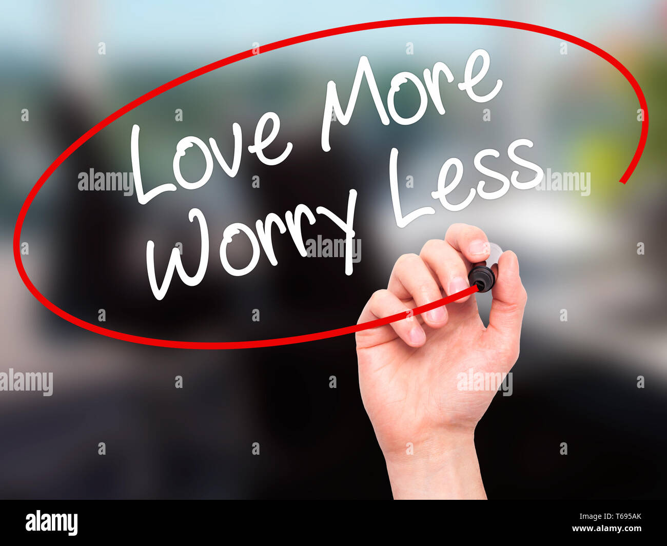 Man Hand writing Love More Worry Less with black marker on visual ...