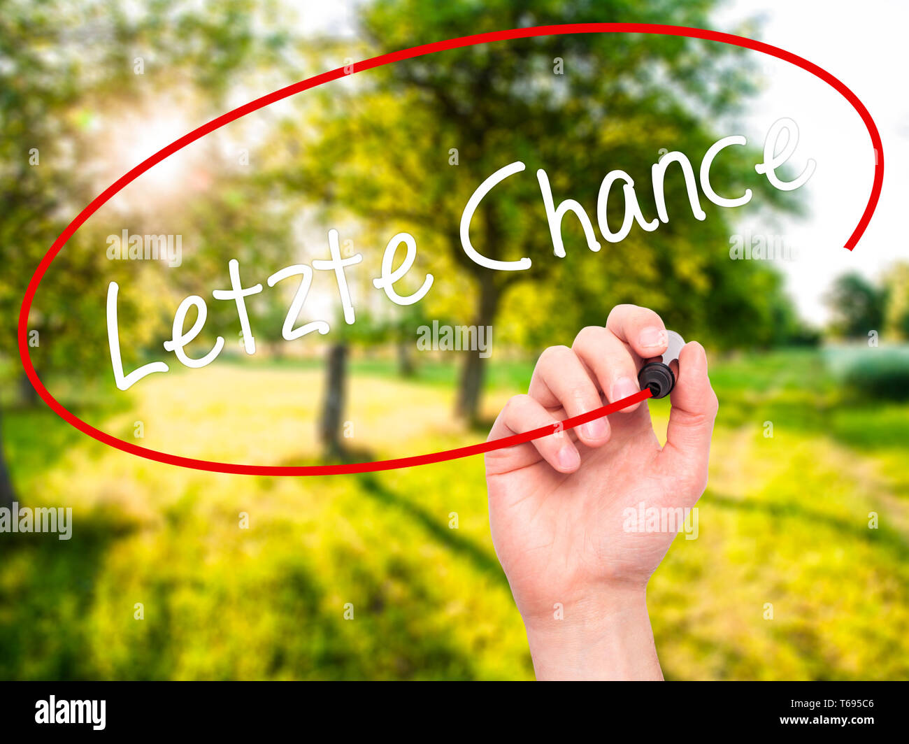 Man Hand writing Letzte Chance (Last Chance in German) with black ...