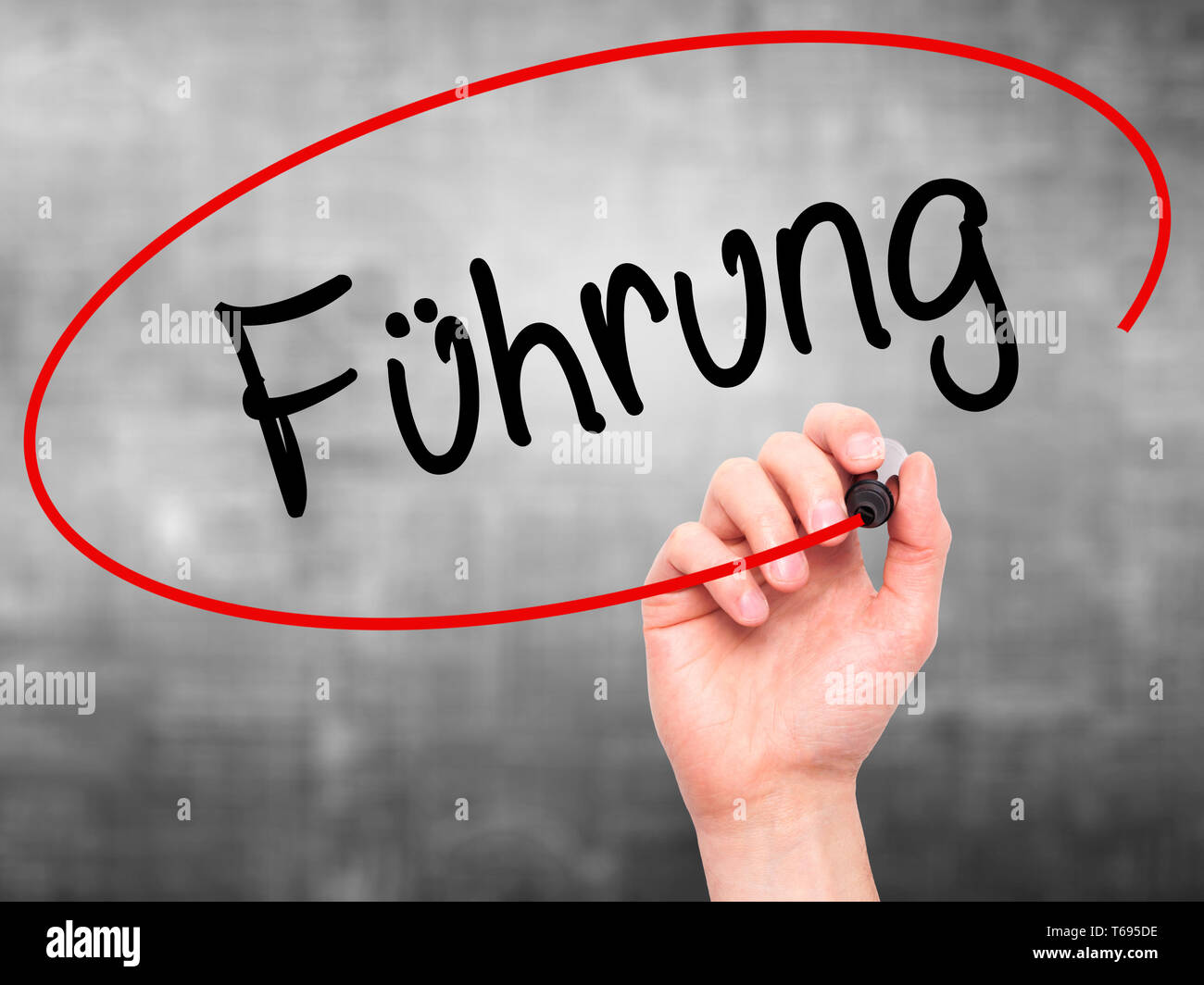 Man Hand writing Fuhrung (Leadership in German) with black marker on ...
