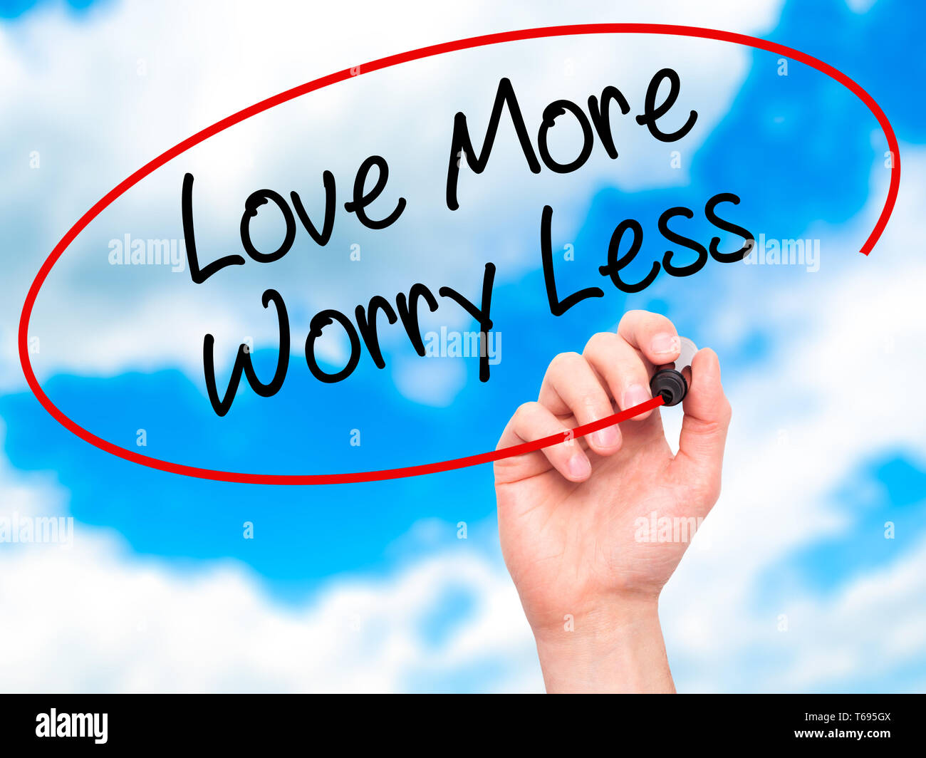 Man Hand writing Love More Worry Less with black marker on visual ...