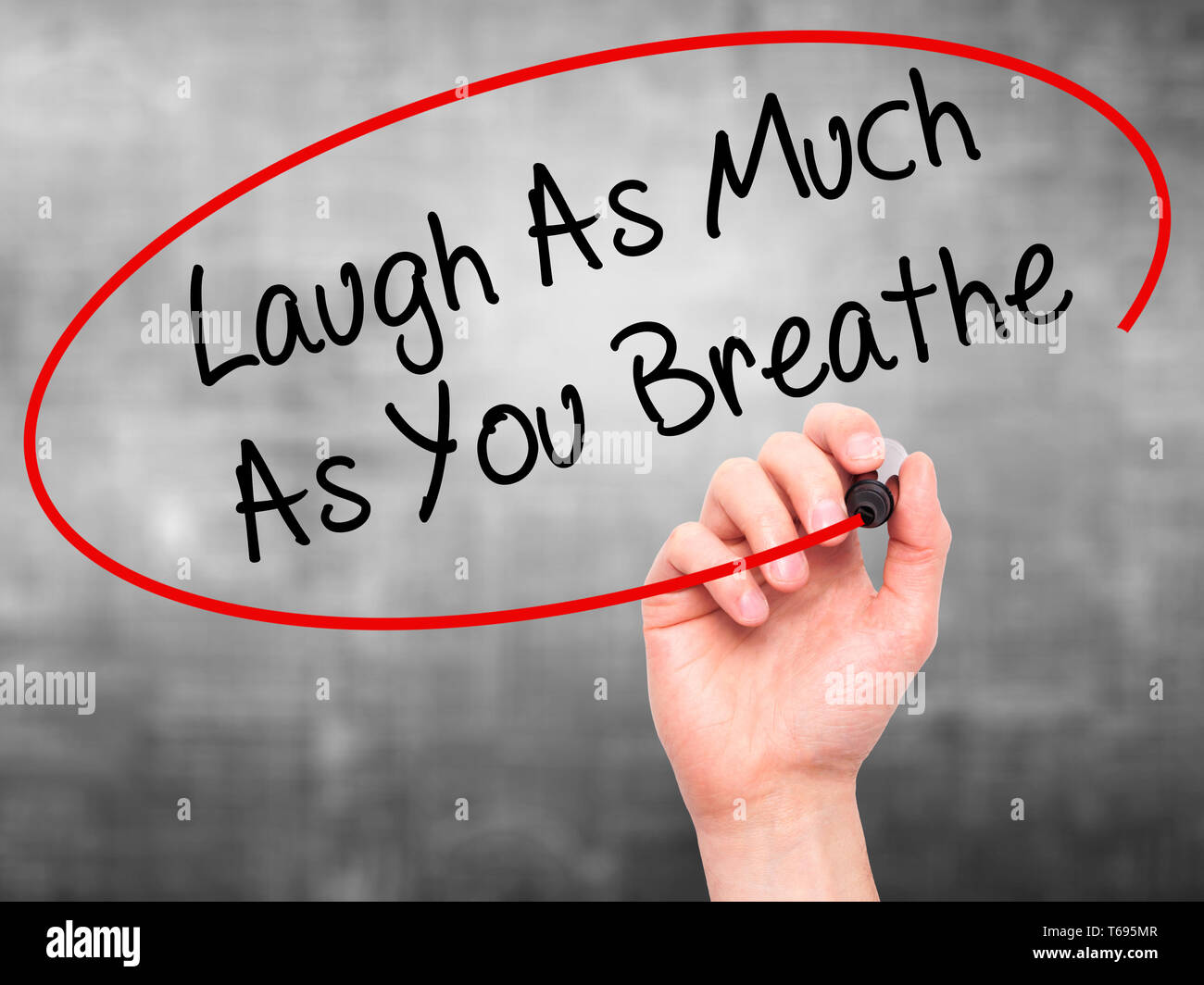 Man Hand writing Laugh As Much As You Breathe with black marker on ...