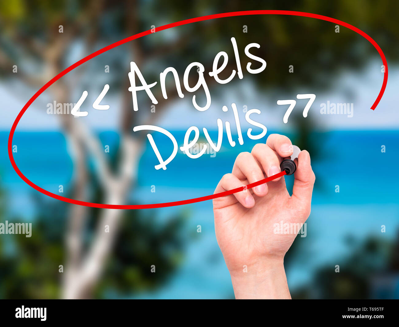 Man Hand writing Angels - Devils with black marker on visual screen ...