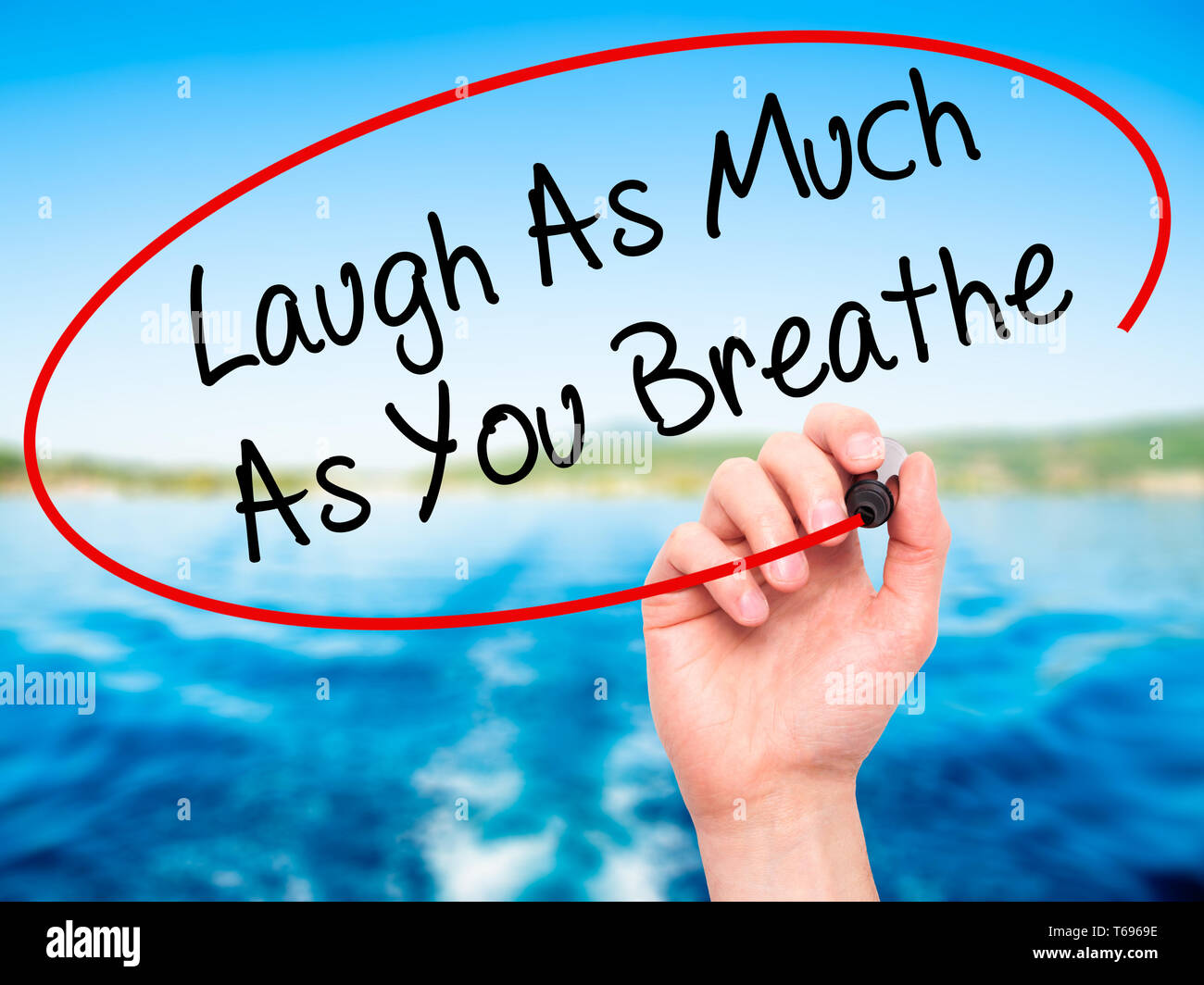 Man Hand writing Laugh As Much As You Breathe with black marker on ...