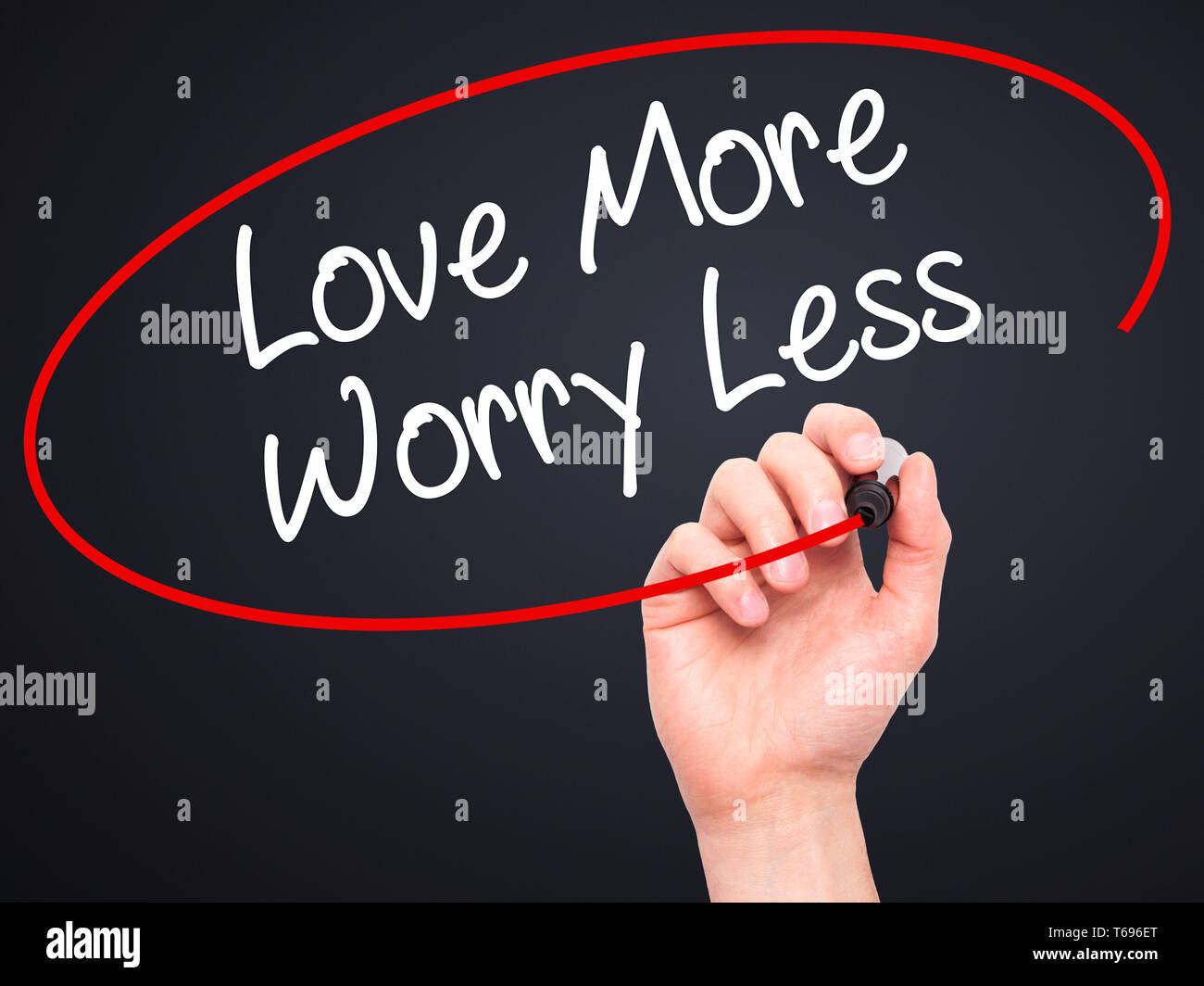 Man Hand writing Love More Worry Less with black marker on visual ...