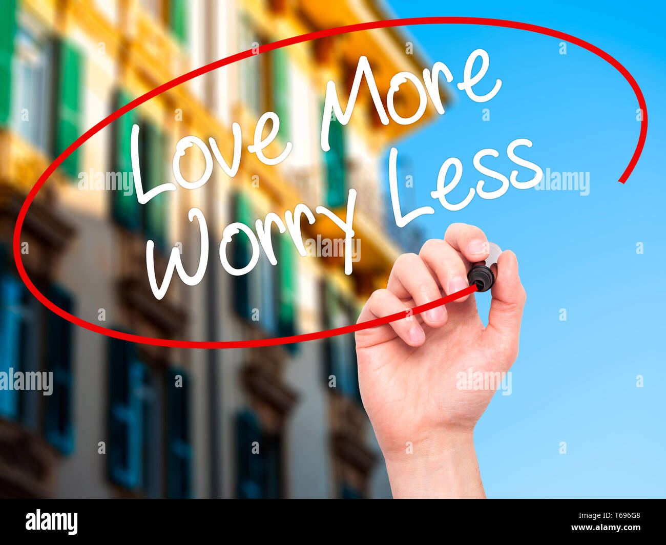 Man Hand writing Love More Worry Less with black marker on visual ...