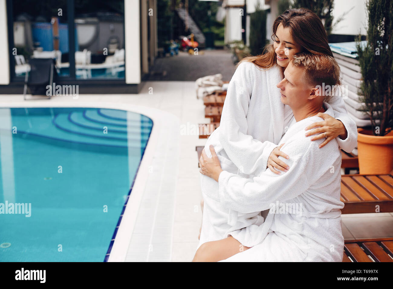 Elegant couple sitting near a swimmingpool Stock Photo - Alamy