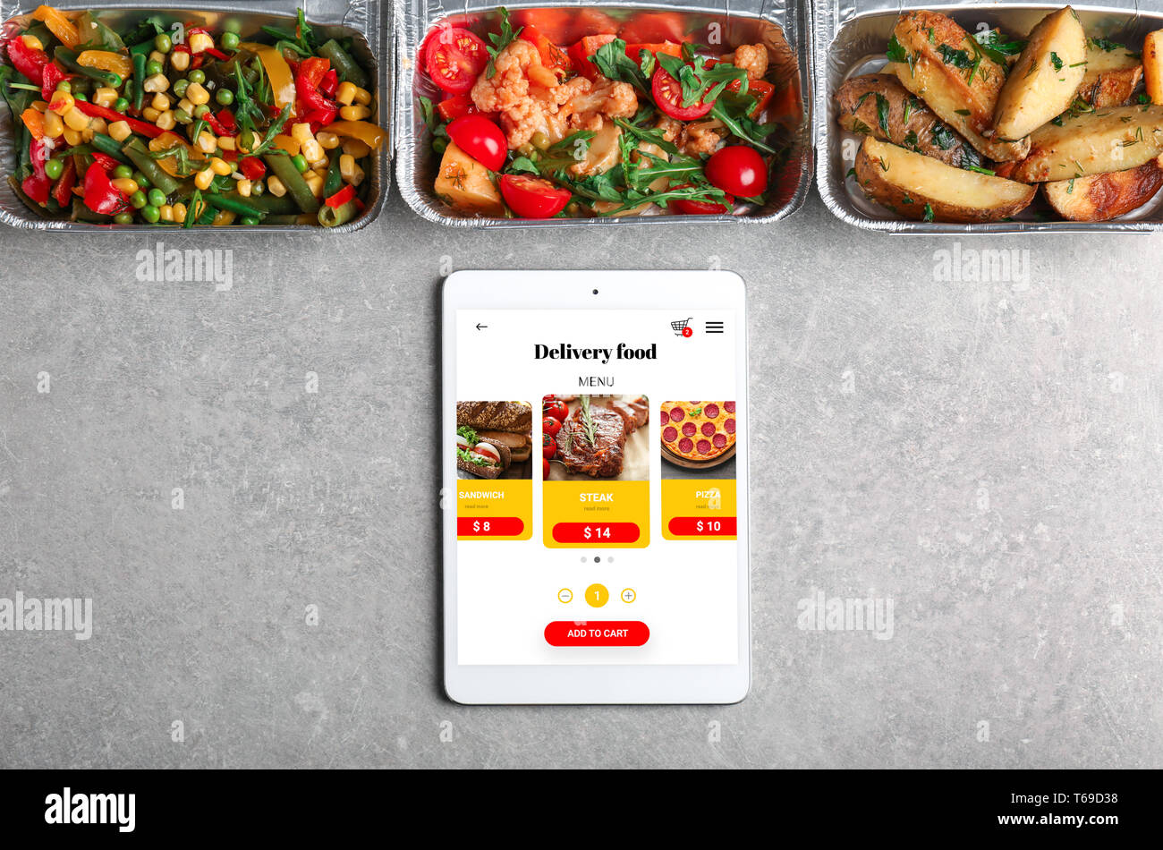 Tablet computer with open page of food delivery site on screen and ...