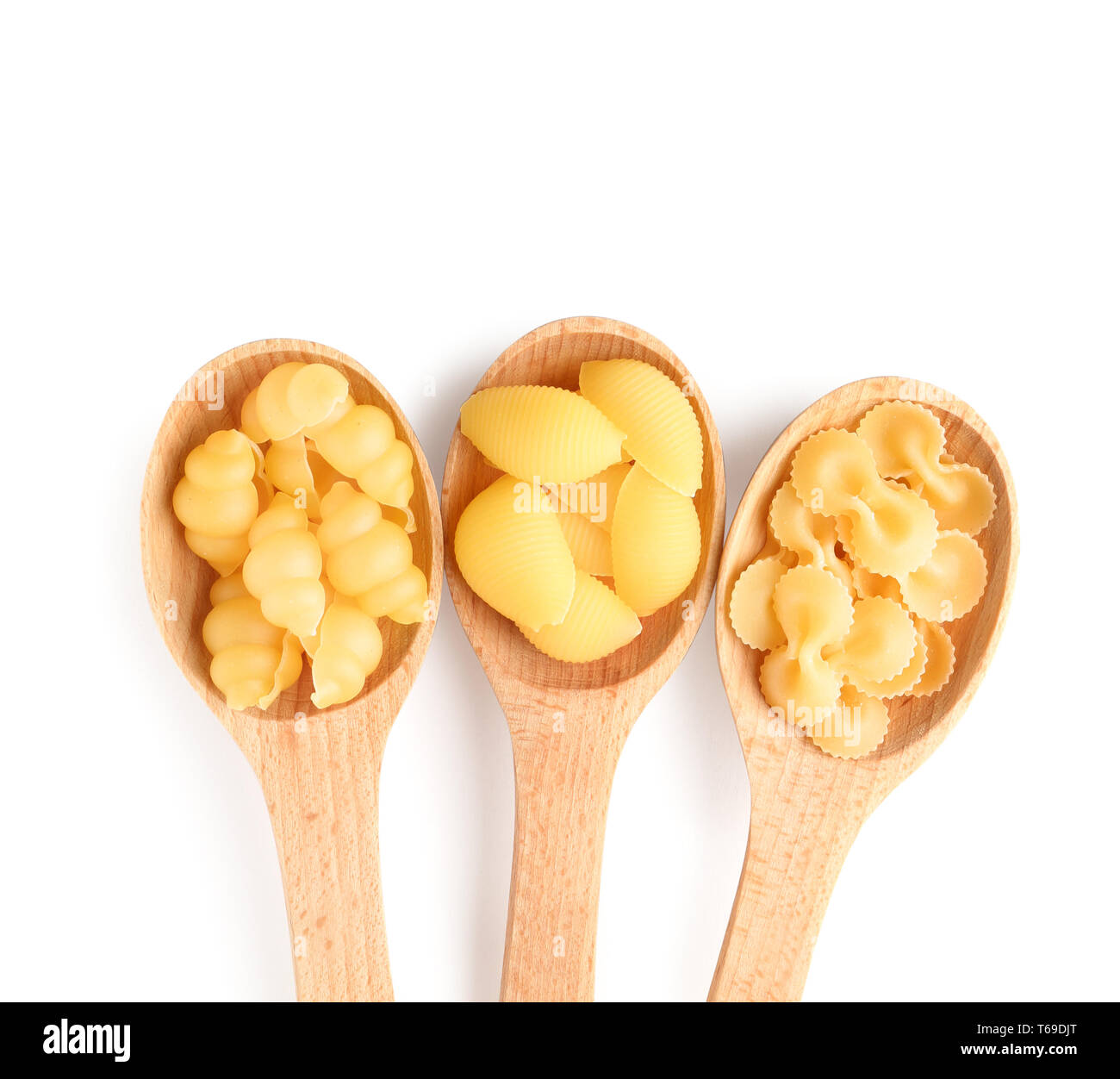 Wooden spoons with different types of pasta on white background Stock ...