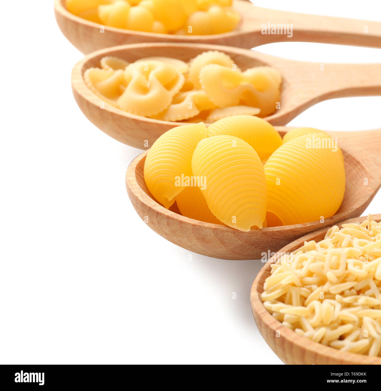 Wooden spoons with different types of pasta on white background Stock ...