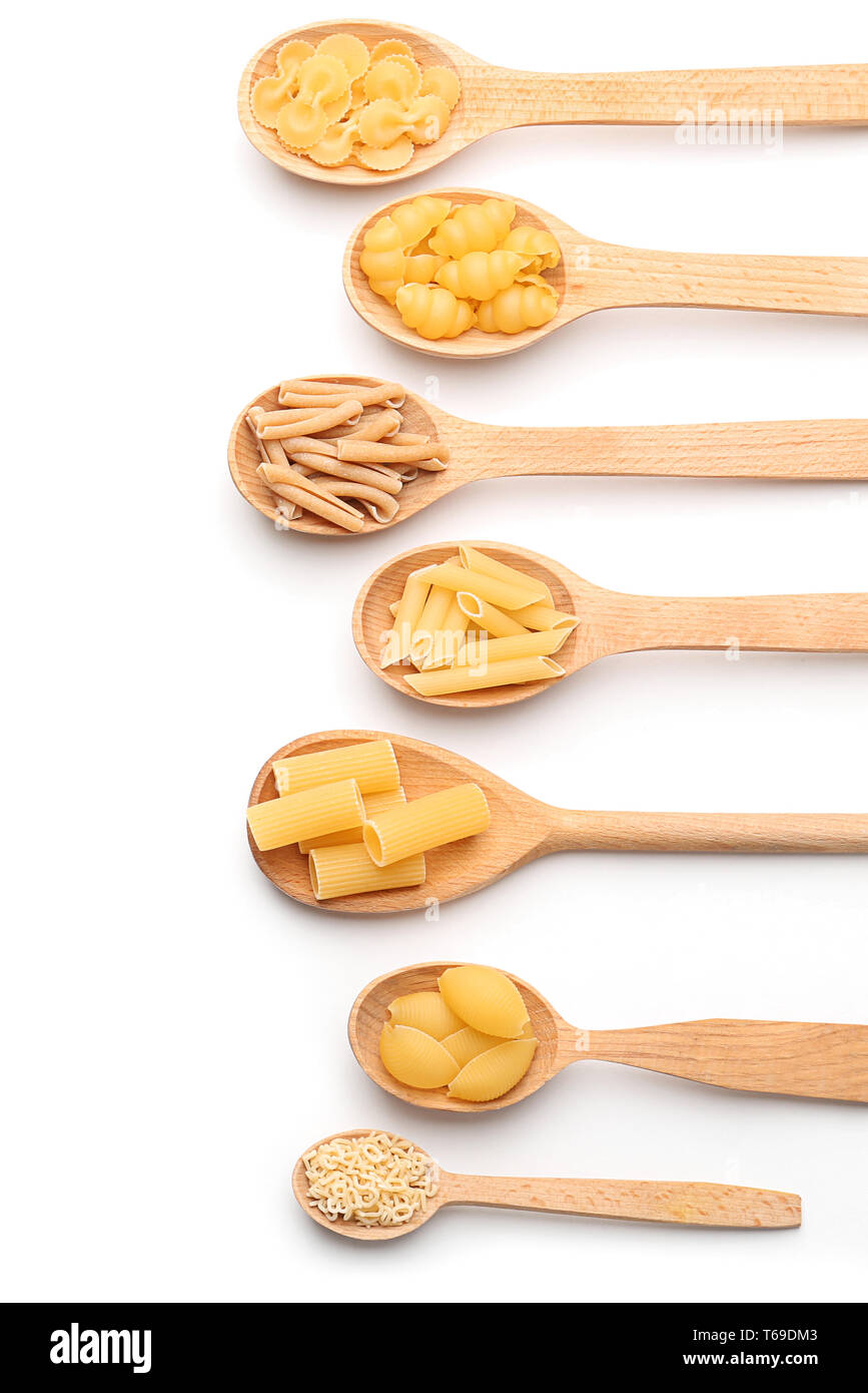 Wooden spoons with different types of pasta on white background Stock ...
