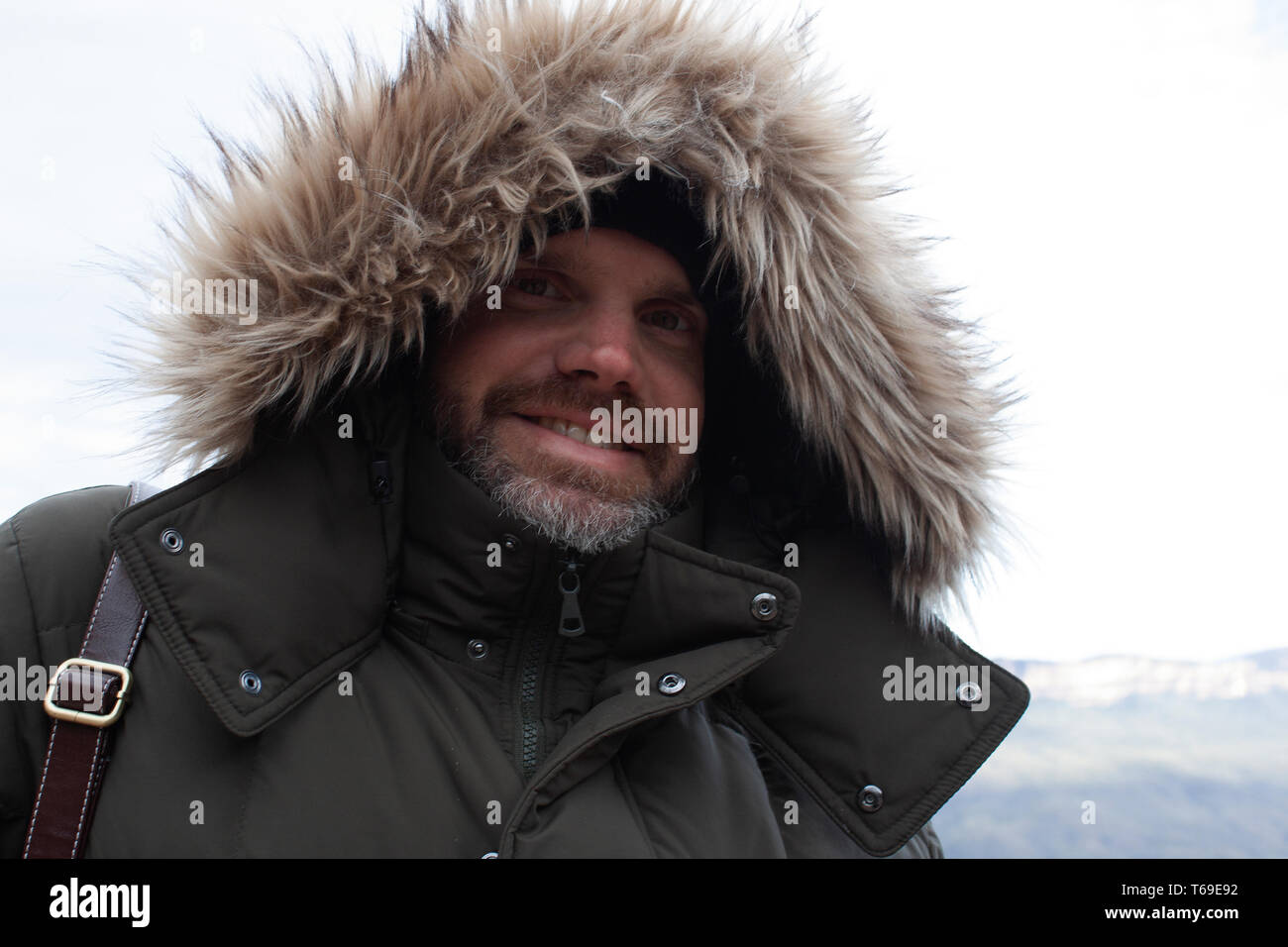Bearded man in hooded jacket smiling Stock Photo - Alamy