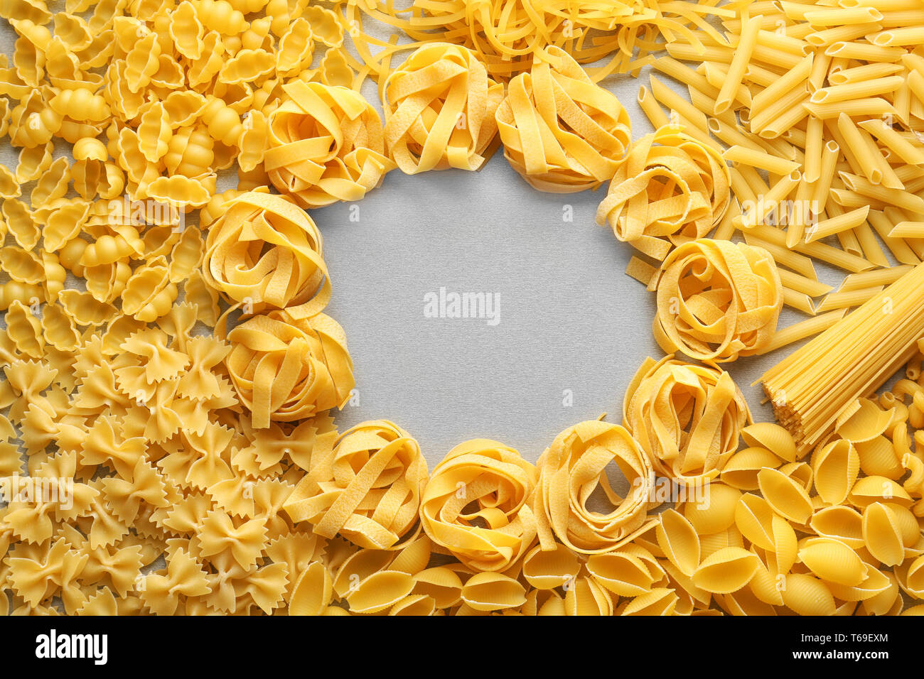 Different uncooked pasta on light background Stock Photo - Alamy