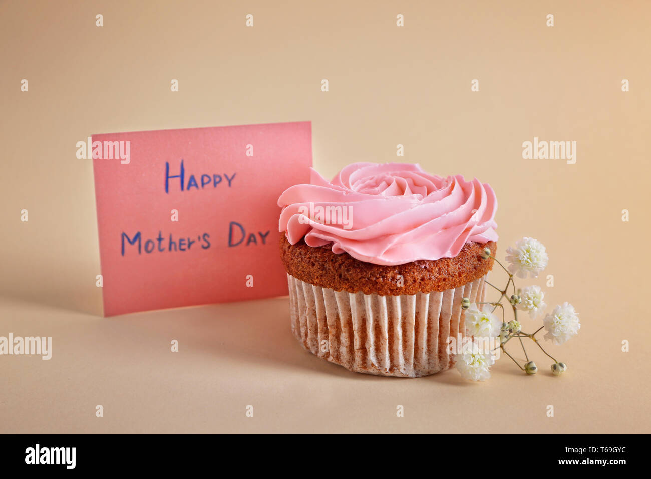 Card with words HAPPY MOTHER'S DAY and tasty cupcake on color ...