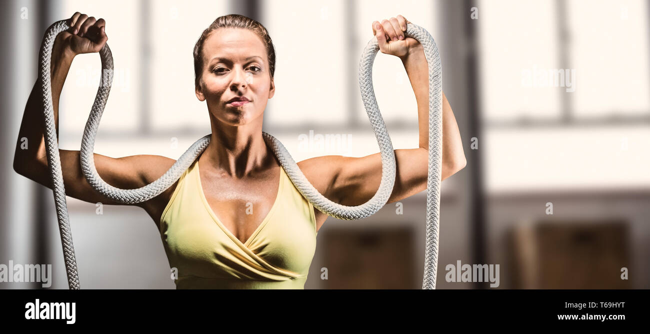 Composite image of healthy woman holding rope around neck with arms ...