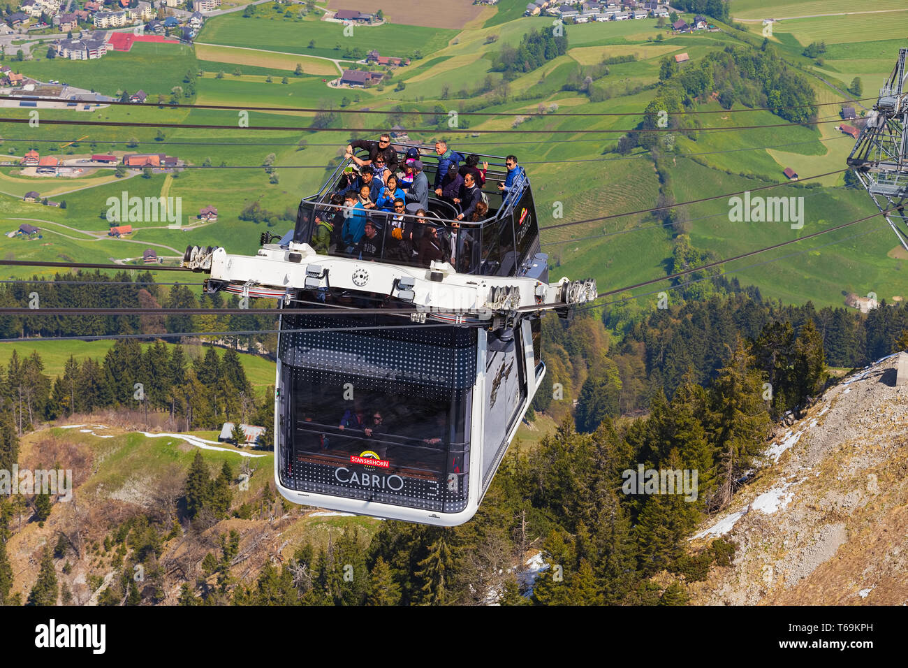A gondola of the Stanserhorn Cabrio overhead cable car approaching the ...