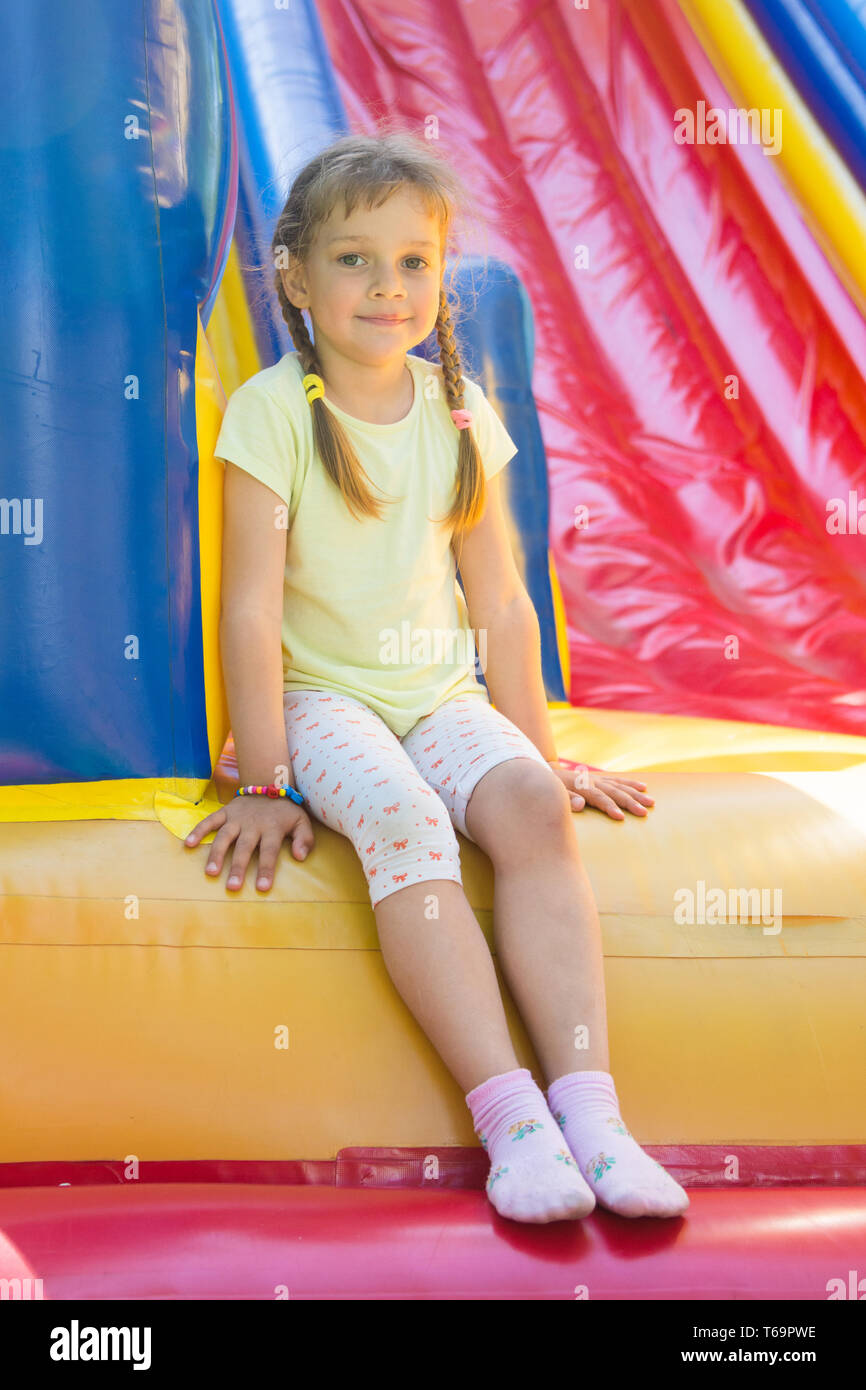 Five-year girl sitting on a big inflatable trampoline Stock Photo - Alamy