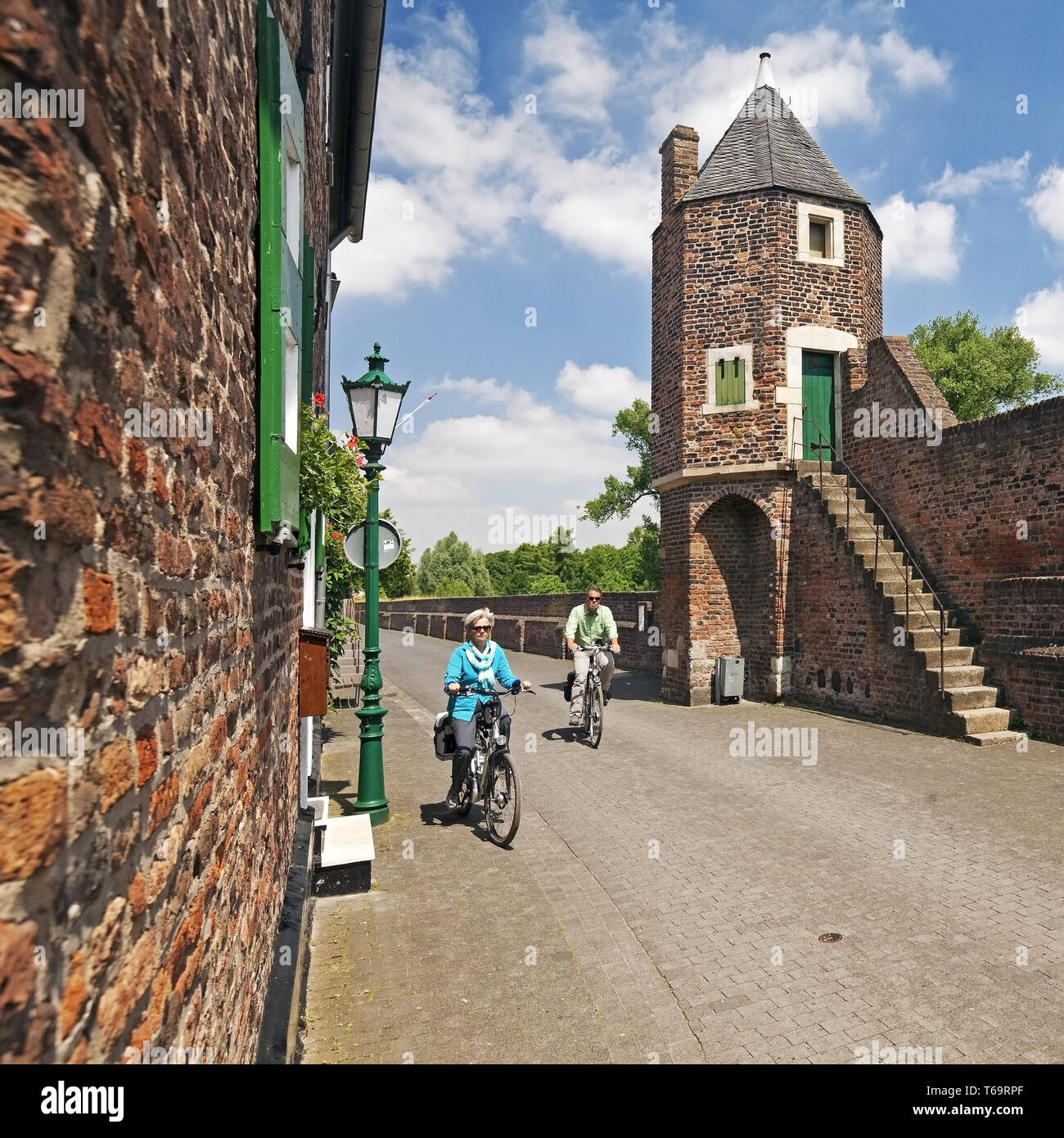 cyclists at the town wall and tower Pfefferbuechse, Zons, Dormagen ...