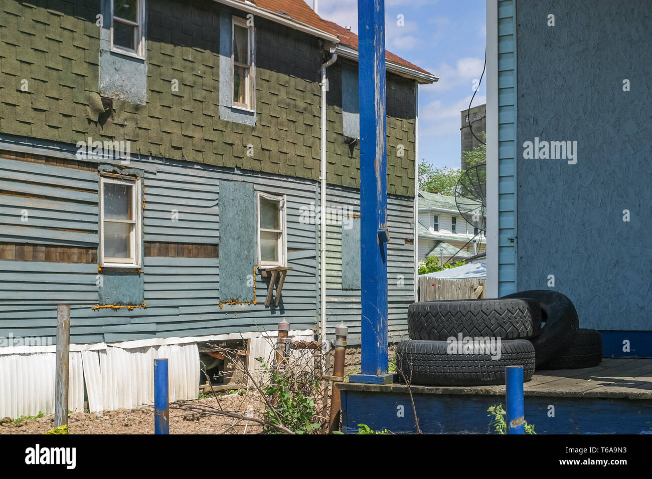Run down housing with tires on front porch Stock Photo - Alamy