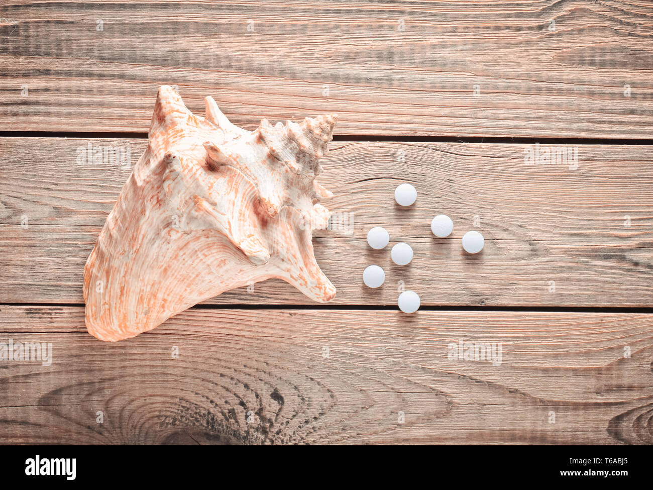 Tablets of calcium and shell on a wooden table. Medical concept ...