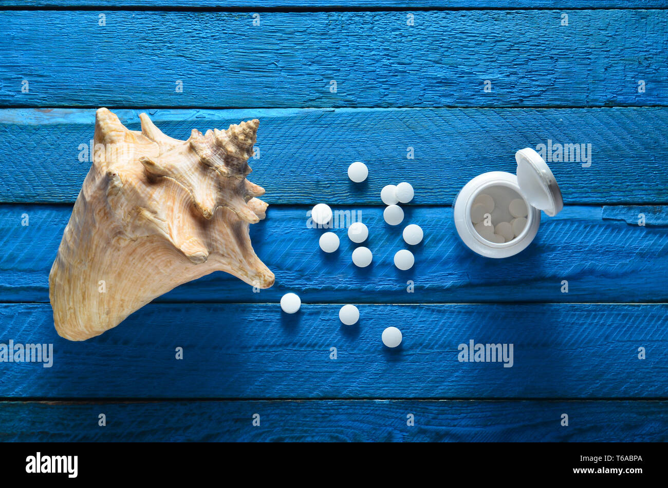 Minerals for health and beauty. Tablets of calcium, shell on a blue ...