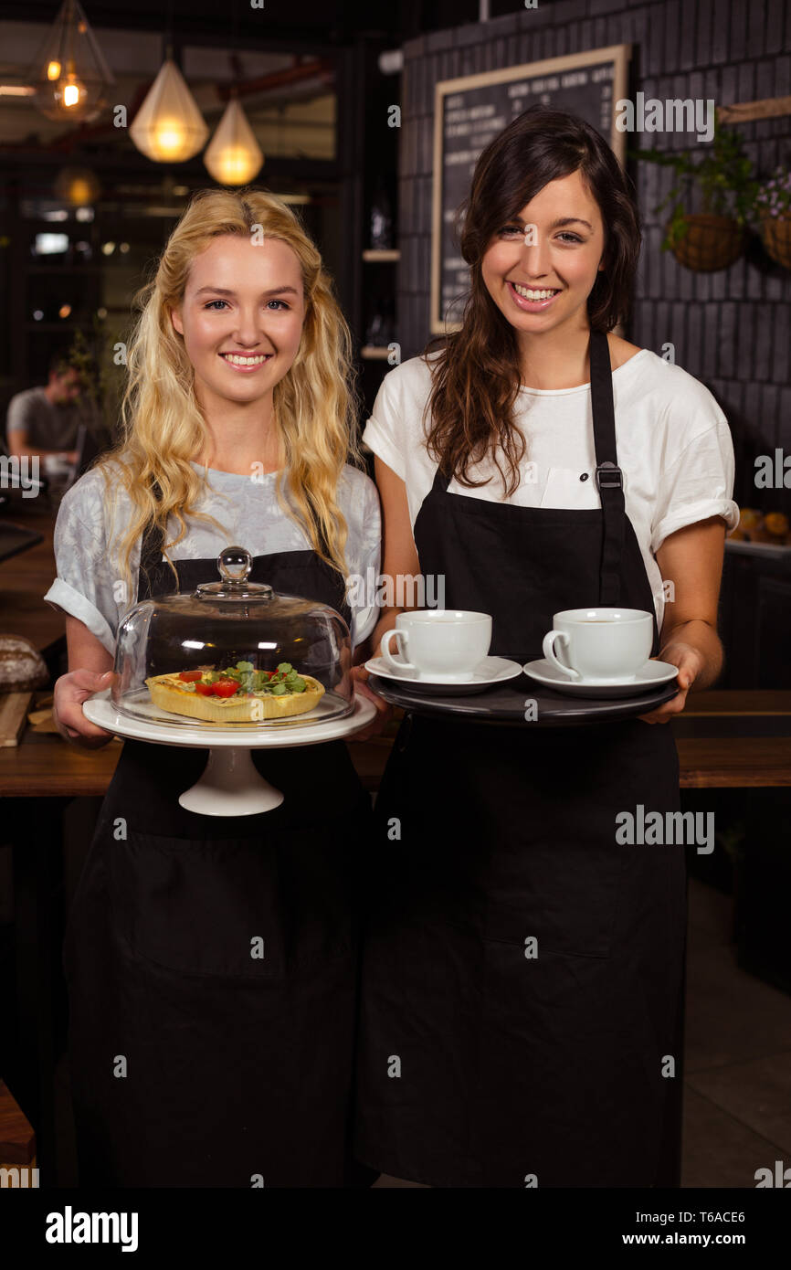 Pretty waitresses posing in front of the counter presenting coffee and ...