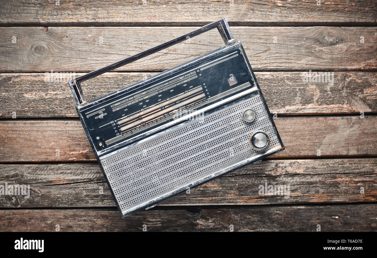 Radio receiver from the 70s on a rustic wooden background. Top view ...