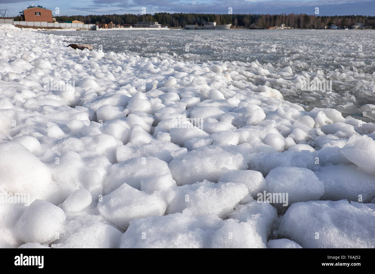 Lumps of snow and ice frazil on the surface of the freezing river water ...