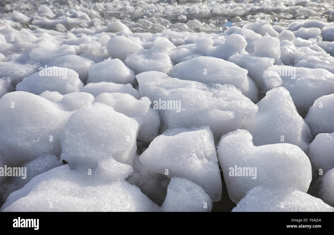Lumps of snow and ice frazil on the surface of the freezing river water ...