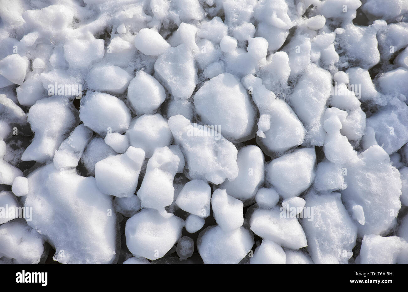 Lumps of snow and ice frazil on the surface of the freezing river water ...