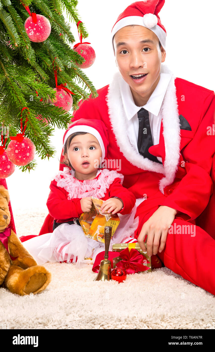 Happy family in Christmas eve at home sitting near decorated fir tree ...