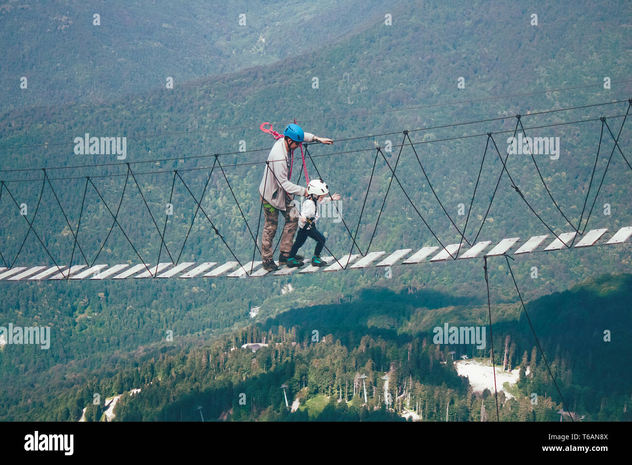 Man and boy walk along the rope bridge. Joint family leisure spending ...