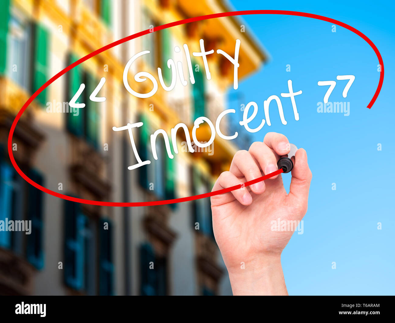 Man Hand writing Guilty - Innocent with black marker on visual screen ...