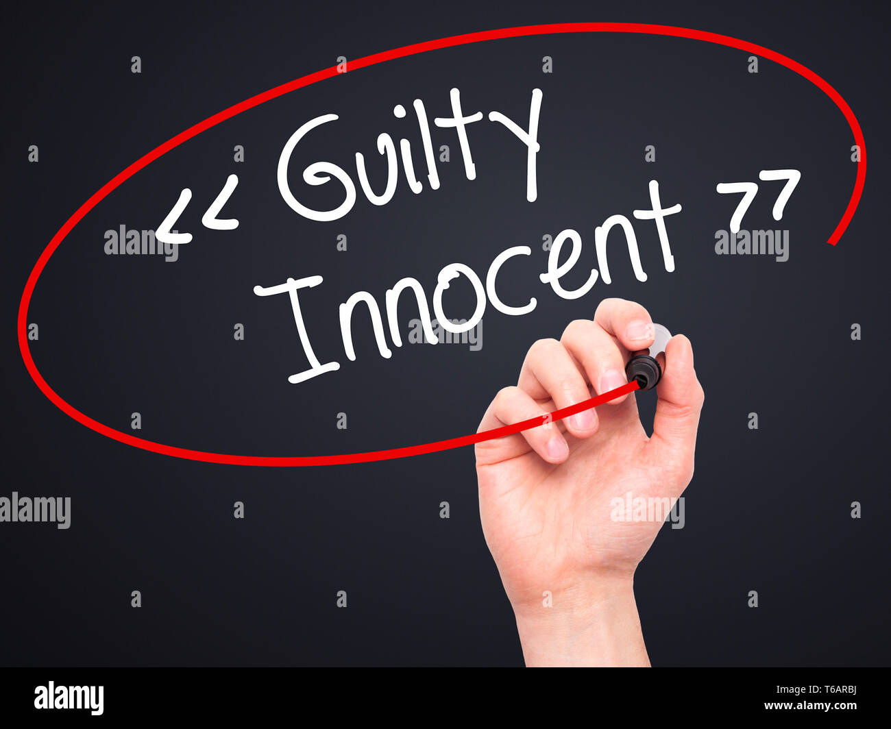 Man Hand writing Guilty - Innocent with black marker on visual screen ...