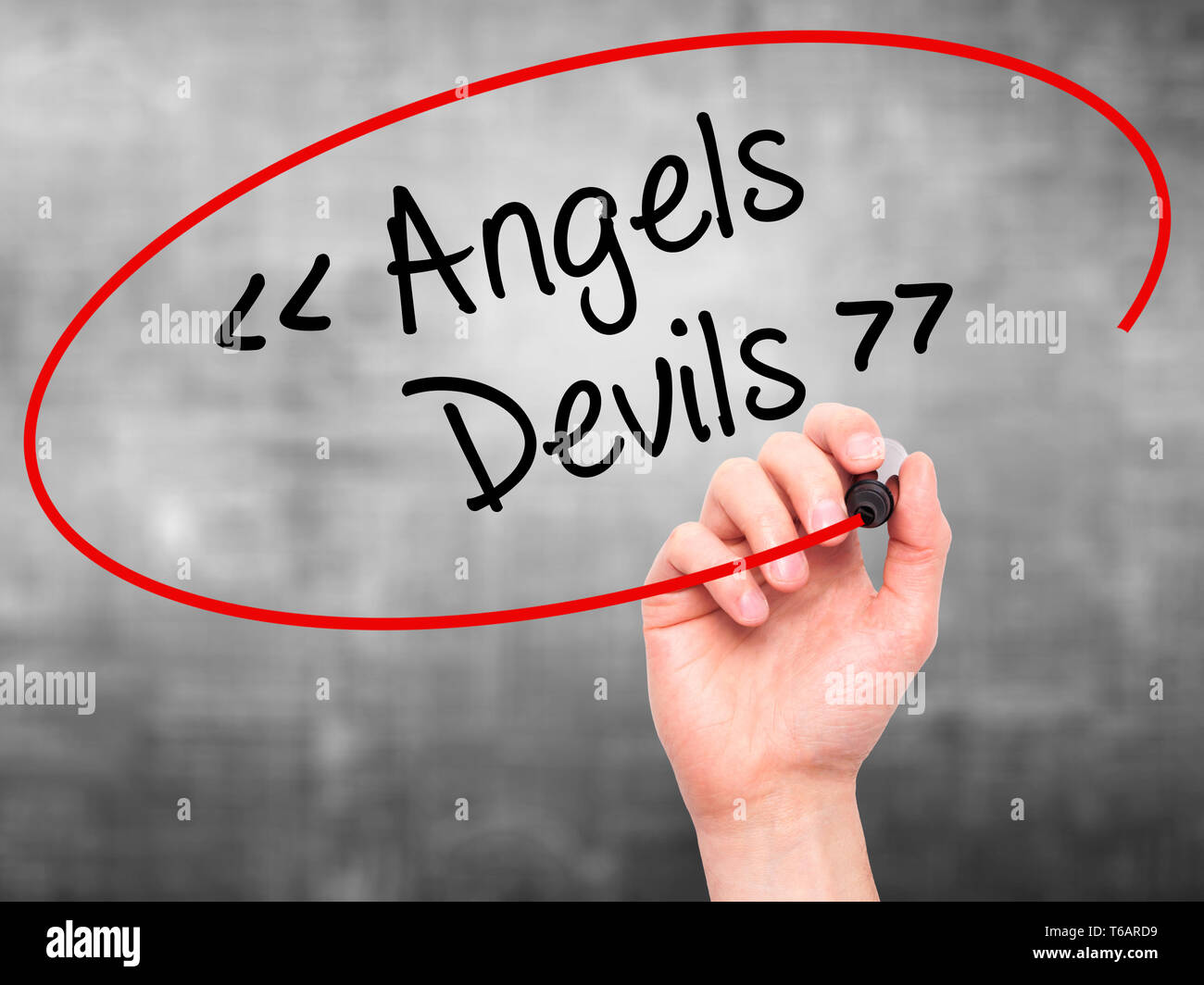 Man Hand writing Angels - Devils with black marker on visual screen ...